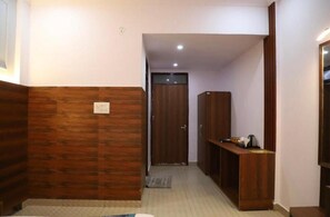 Um corredor com painéis de madeira, uma porta e uma pequena mesa com objetos sobre ela.
