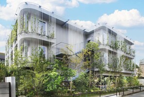 Um edifício moderno com elementos de jardim vertical, varandas e fachada curva.