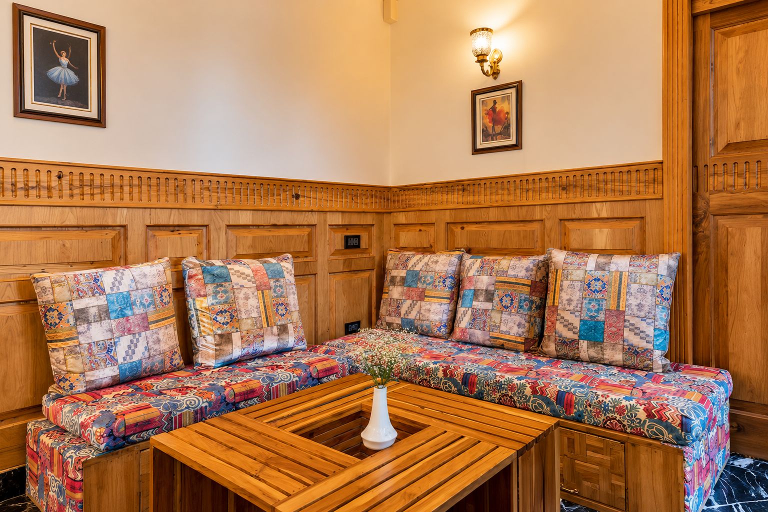 Uma área de estar aconchegante com um banco de madeira e uma mesa, com uma capa de banco acolchoada e colorida e um vaso branco.