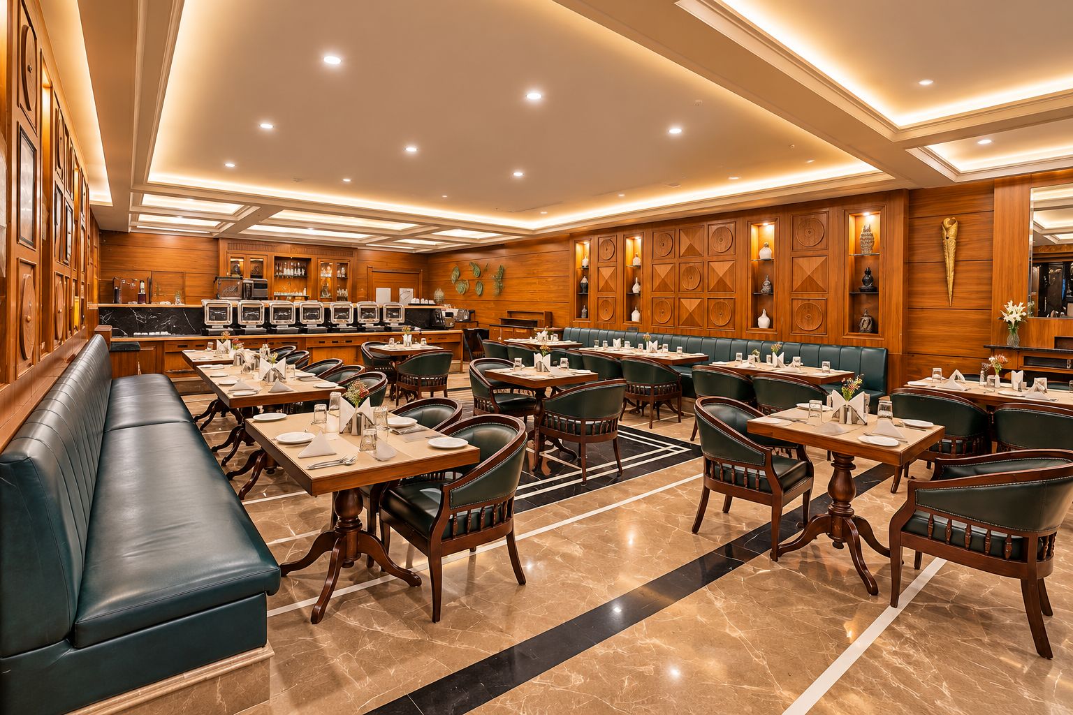 Ampla área de jantar de hotel com várias mesas e cabines, painéis de madeira nas paredes e um design de teto moderno.