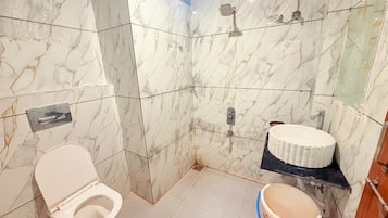 Casa de banho com sanita, lavatório e chuveiro.