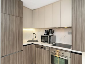 Cozinha moderna equipada com lava-louças embutida, micro-ondas e fogão.