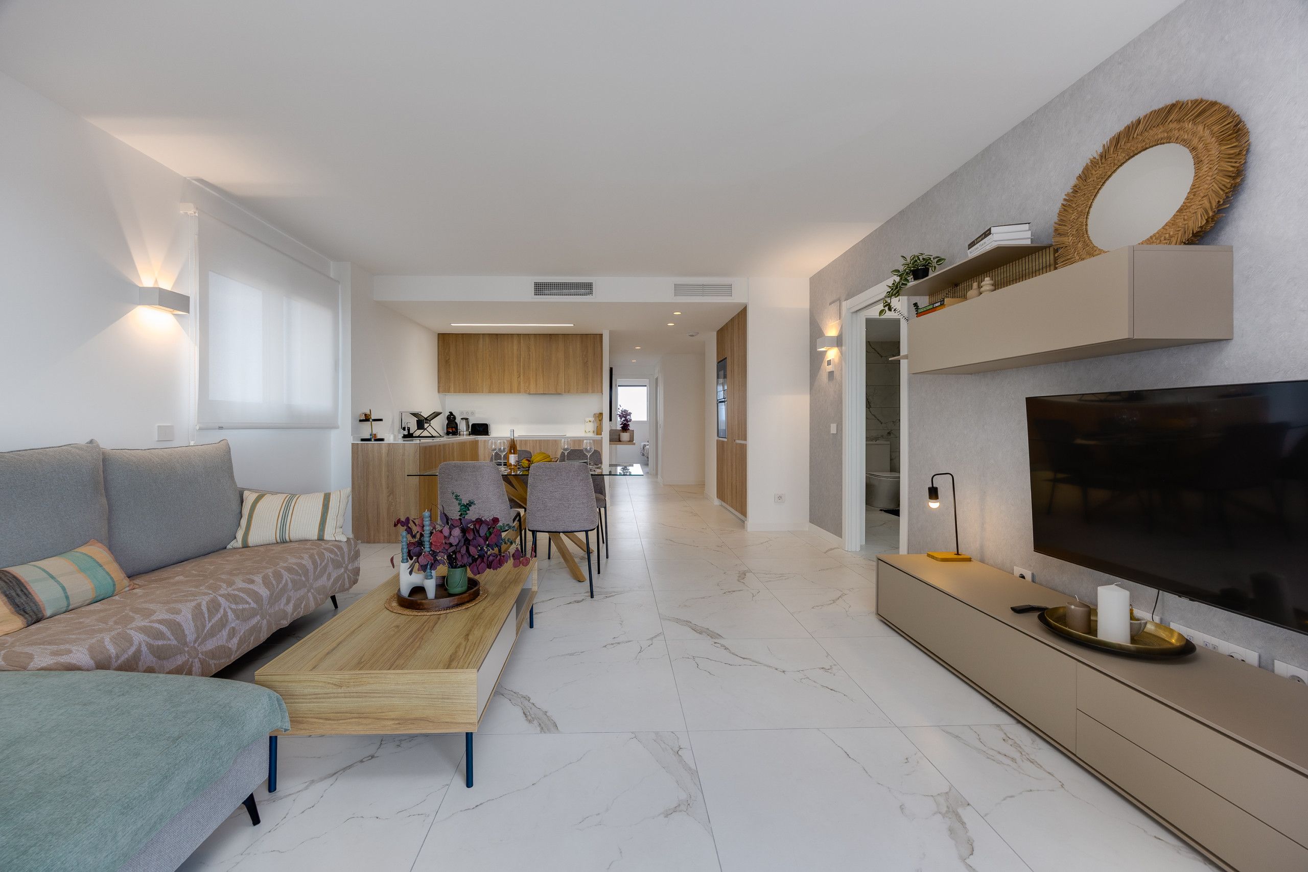 Uma sala de estar moderna com sofá, mesa de centro e TV.