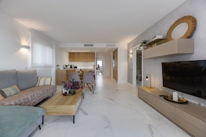 Uma sala de estar moderna com sofá, mesa de centro e TV.