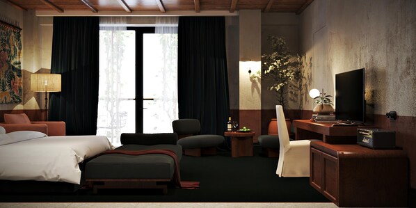 Quarto de hotel com cama, duas poltronas, escrivaninha com computador, televisão e janela com cortinas.