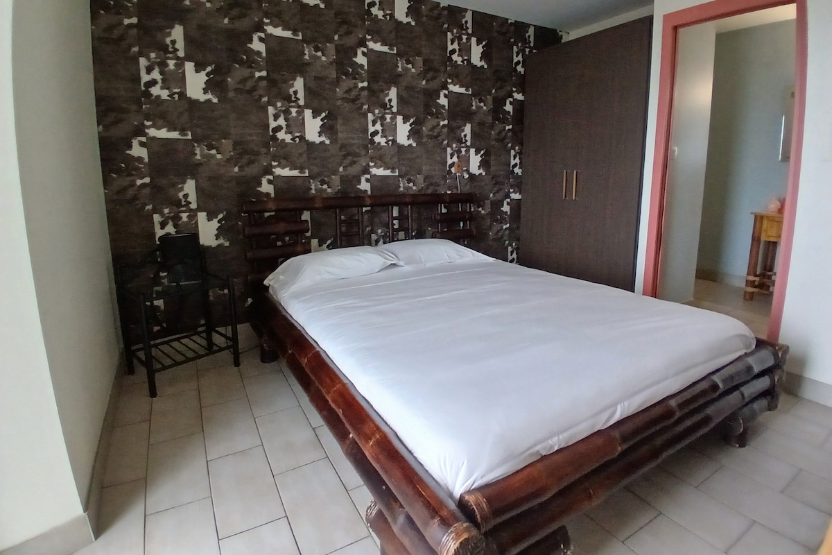 Quarto com cama, guarda-roupa e parede com padrão de camuflagem.