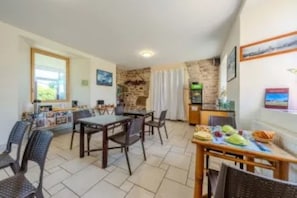 Um quarto com uma mesa de jantar, cadeiras, lareira e televisão.