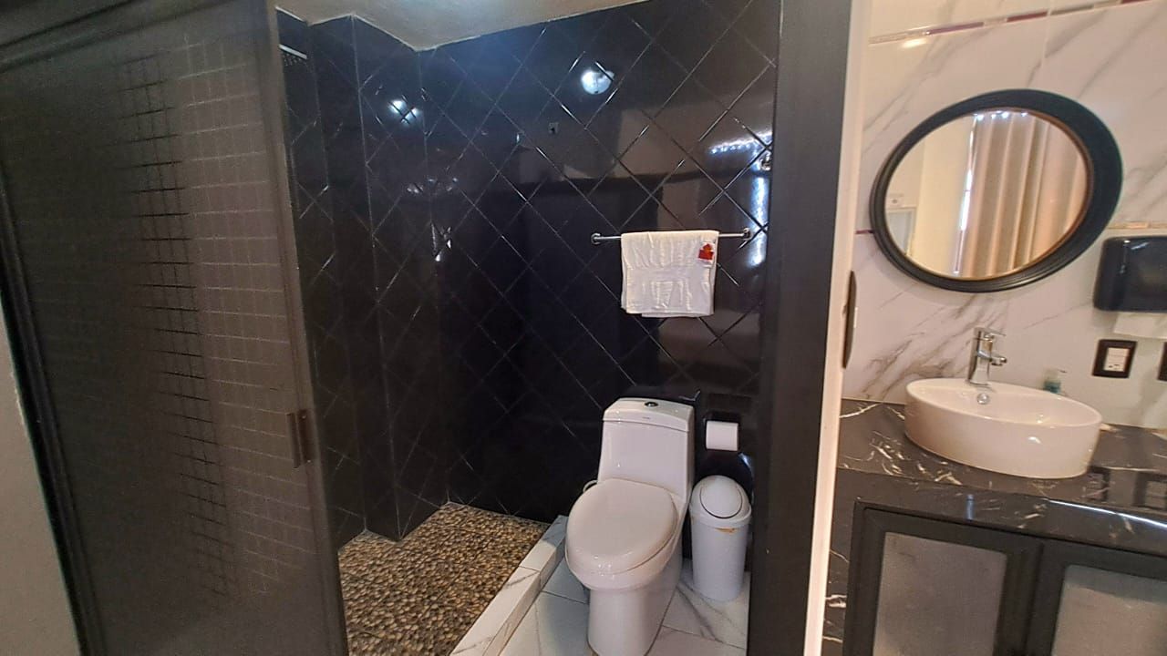 Uma casa de banho com sanita, bidé e lavatório.