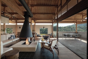 Um interior moderno com lareira, área de estar e vista para o exterior.