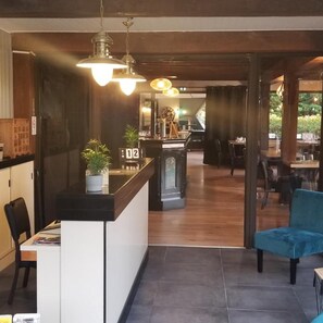 Um restaurante com balcão, área de estar e vista para o exterior.