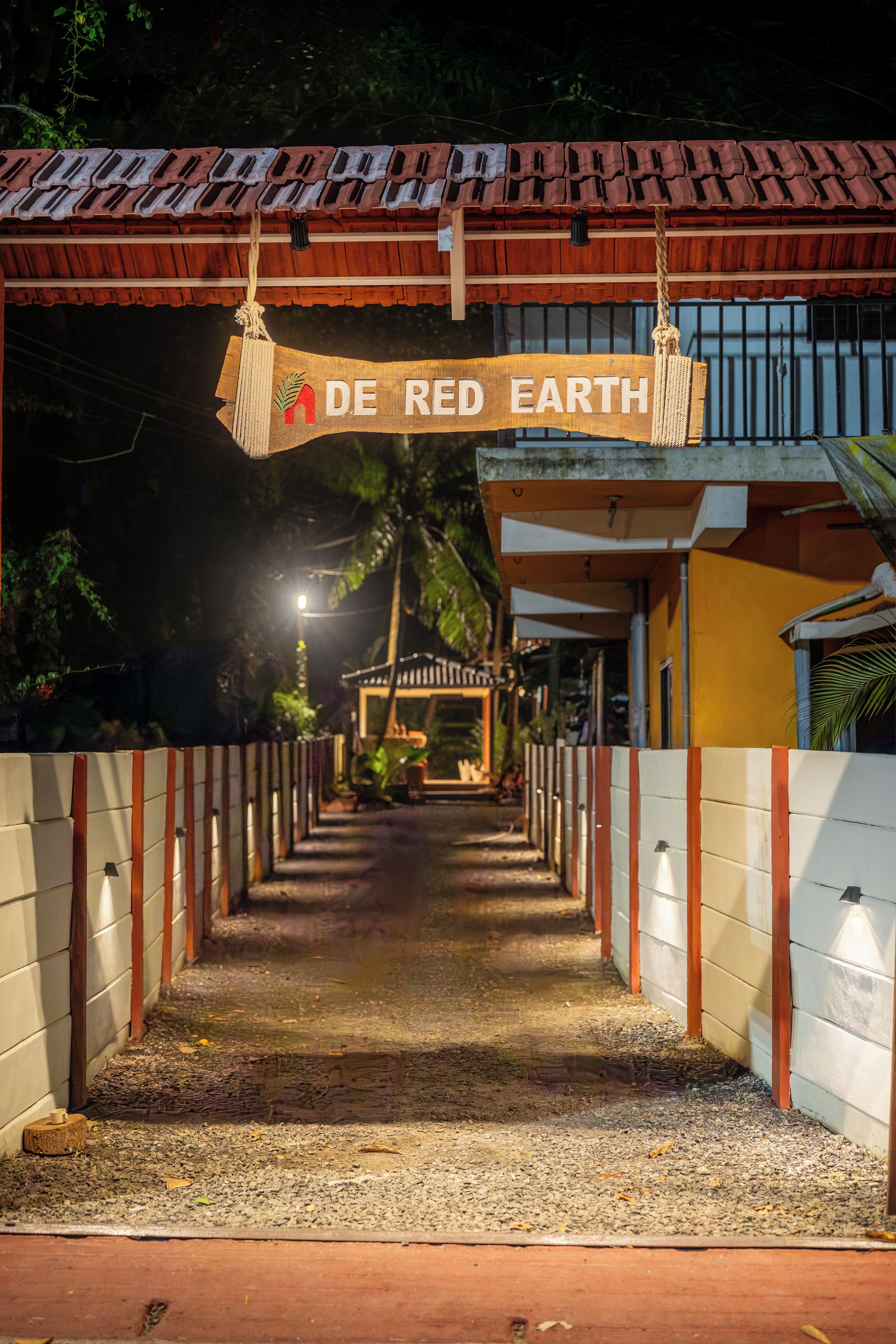 Um caminho leva a um edifício com uma placa que diz 'DE RED EARTH'.
