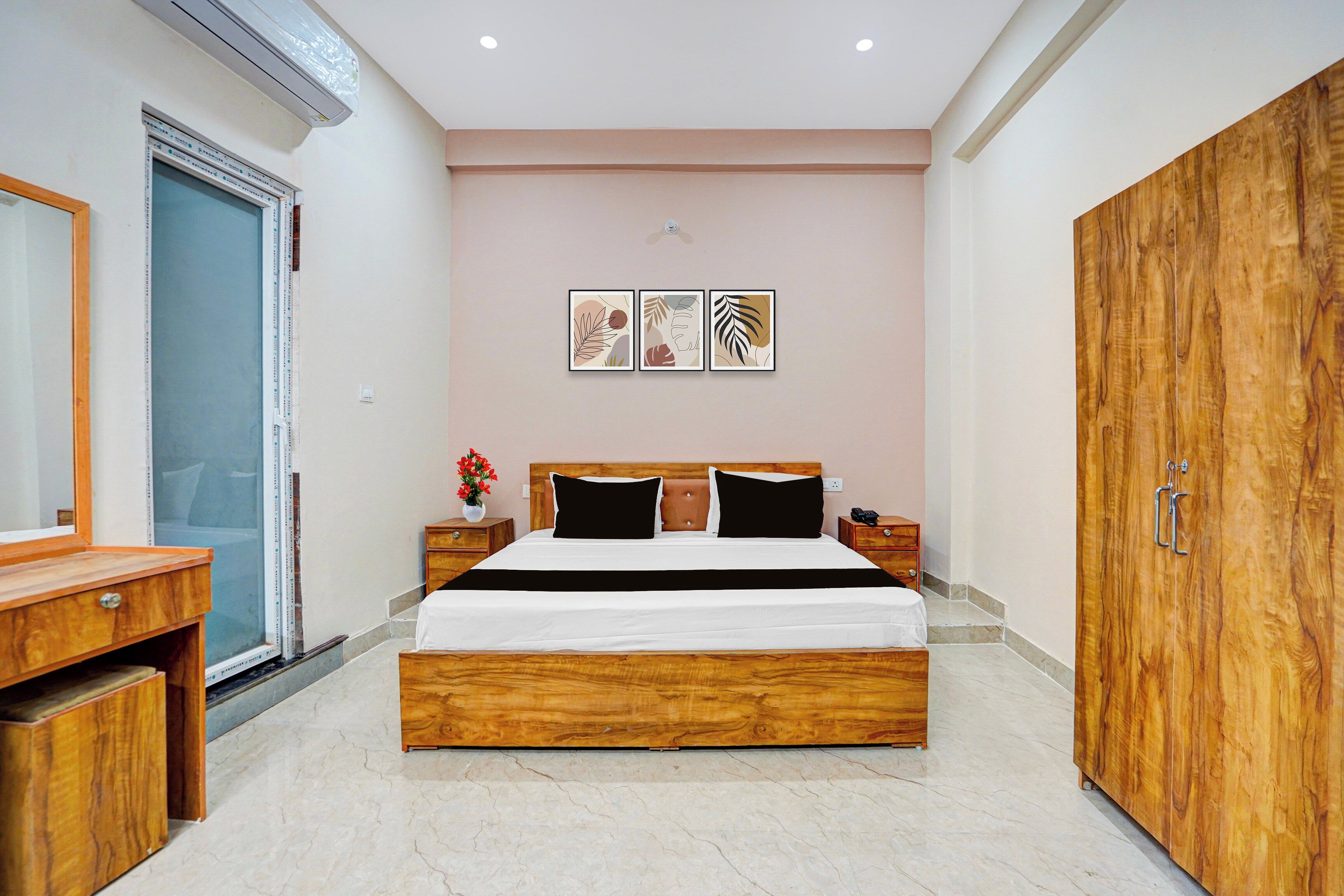 Quarto de hotel com cama de madeira, guarda-roupa de madeira, mesa de cabeceira e espelho.
