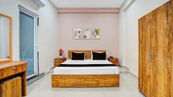 Quarto de hotel com cama de madeira, guarda-roupa de madeira, mesa de cabeceira e espelho.