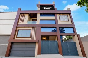 Um edifício moderno de dois andares com uma placa indicando que é administrado pela OYO.