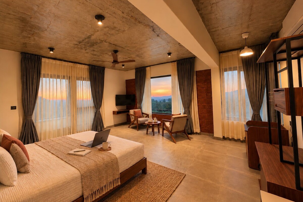 Quarto moderno com cama grande, escrivaninha e televisão.