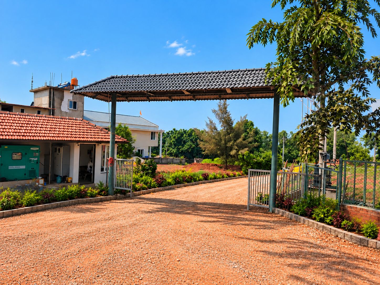 Uma estrada de cascalho leva a um edifício com telhado de telhas e área externa coberta.