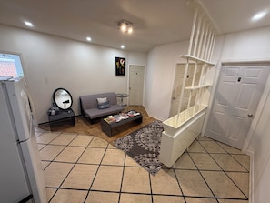 Sala de estar com sofá, mesa de centro e tapete estampado.
