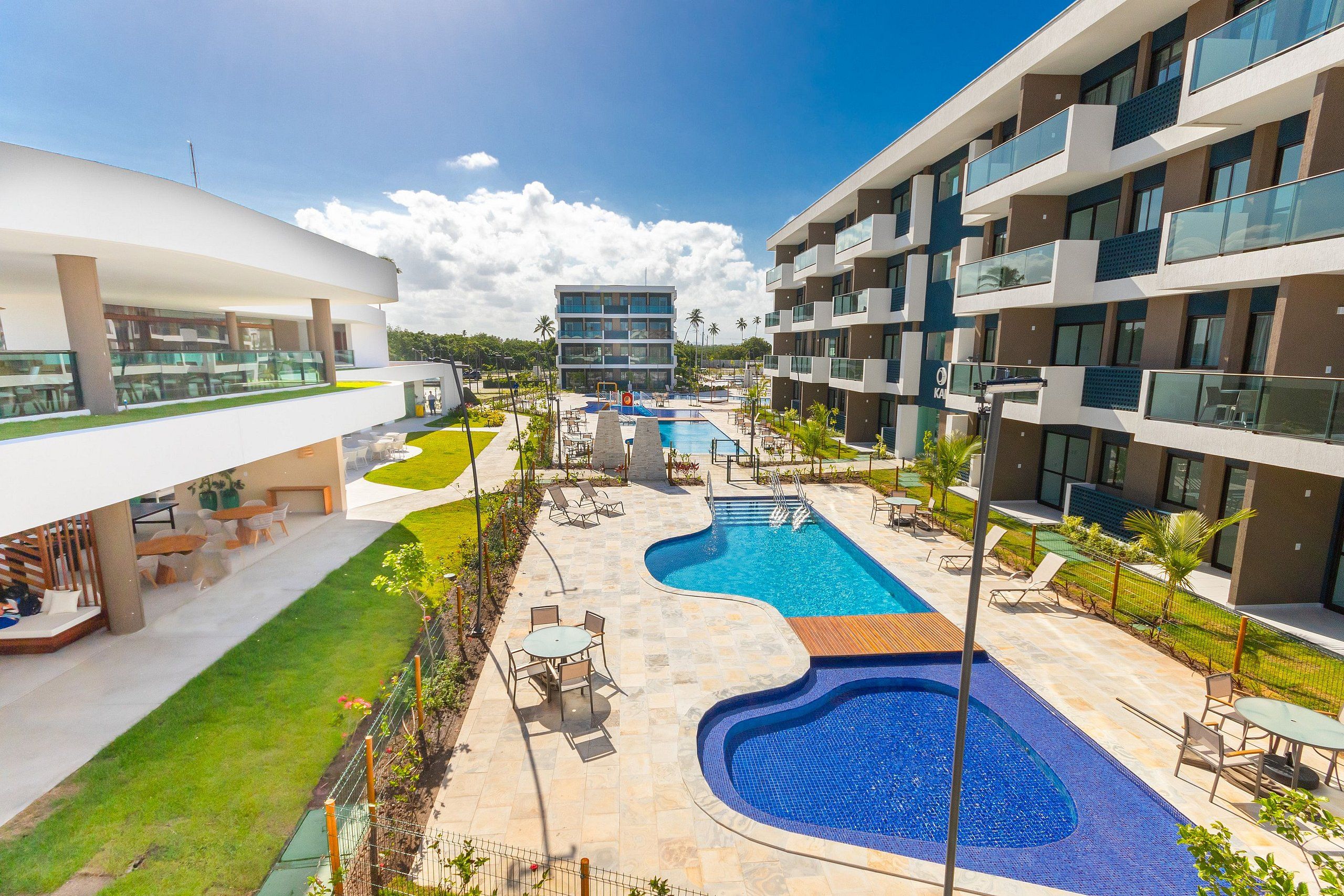 Um hotel moderno com piscina, área de estar ao ar livre e um jardim bem cuidado.