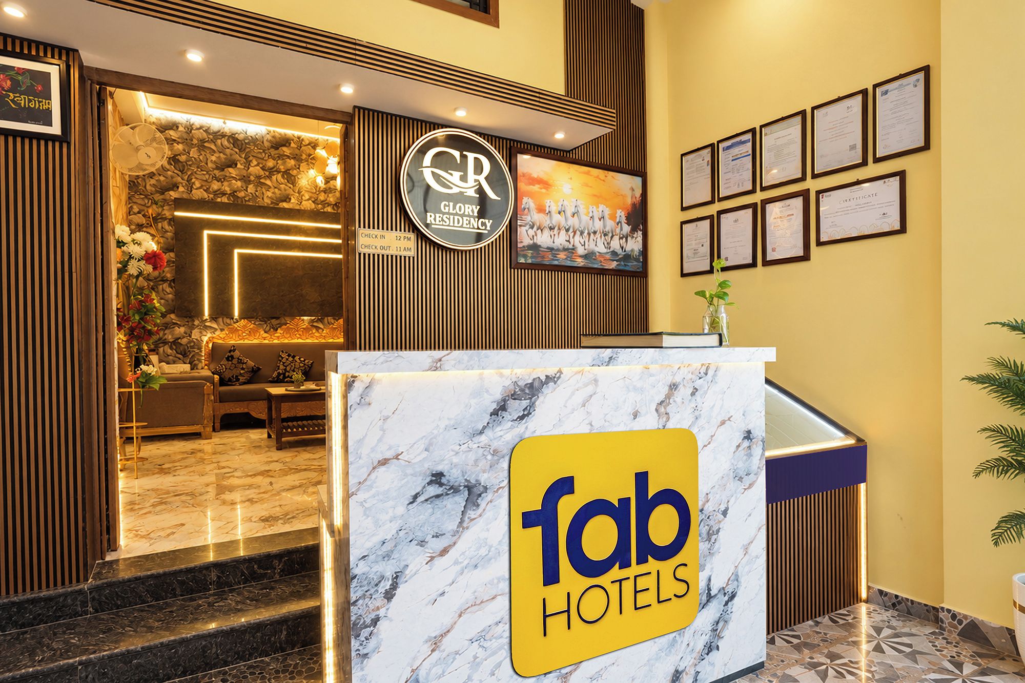 Balcão de recepção de hotel com bancada de mármore e placa indicando 'fab hotels'.