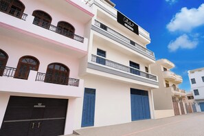 Um edifício com várias andares, varandas, garagem e céu limpo.
