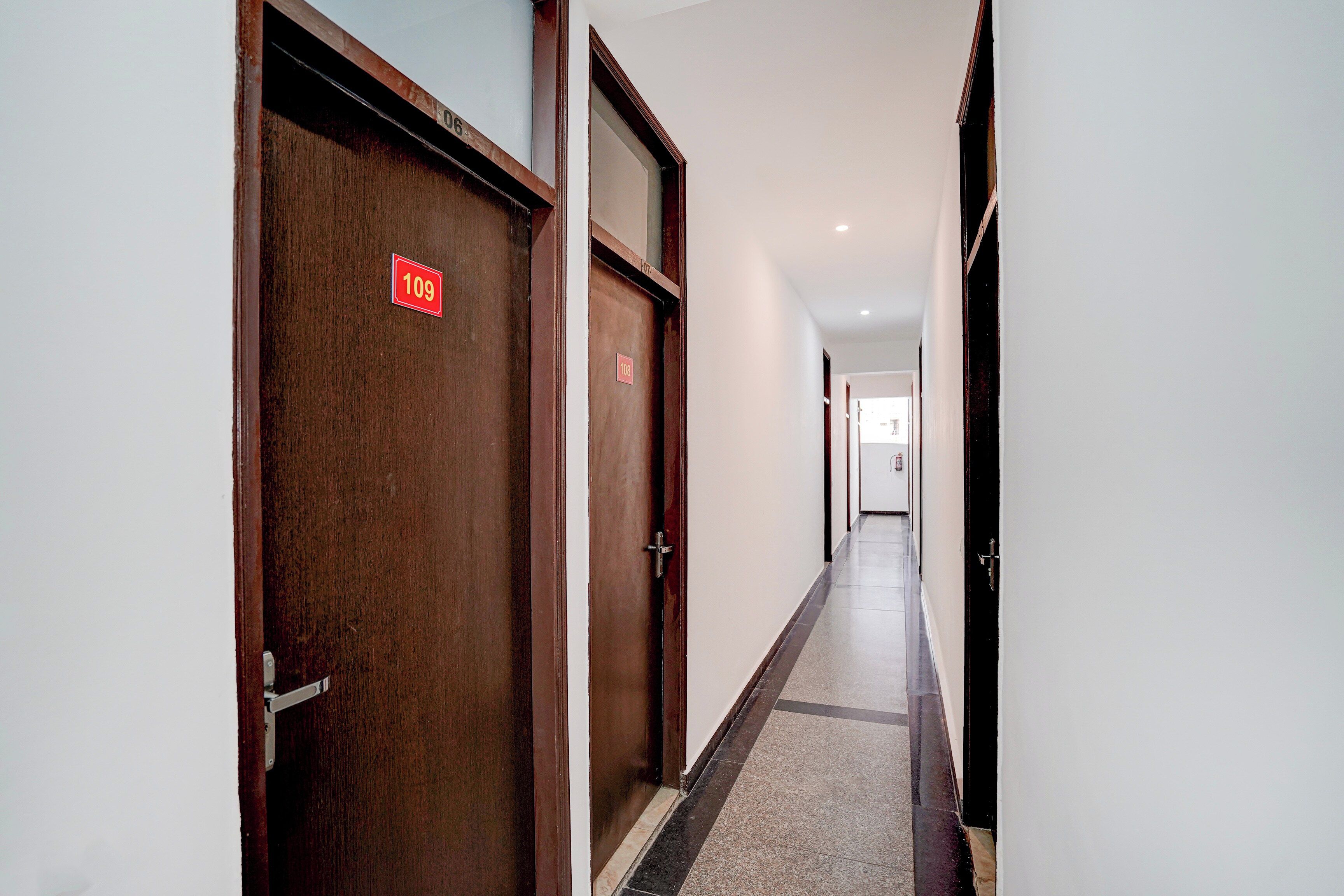 Corredor com portas de madeira identificadas com os números 108 e 109, dando acesso a quartos.