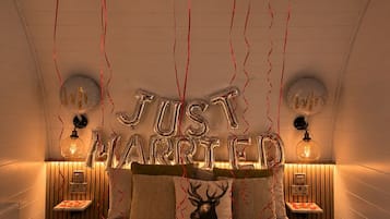 Quarto com cama, travesseiros e placa com a inscrição 'Just Married'.