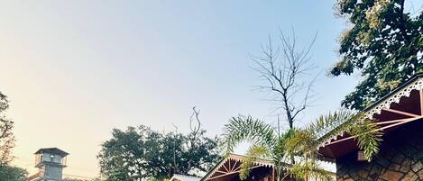 Hotel com fachada de pedra, vários quartos e um gramado bem cuidado.