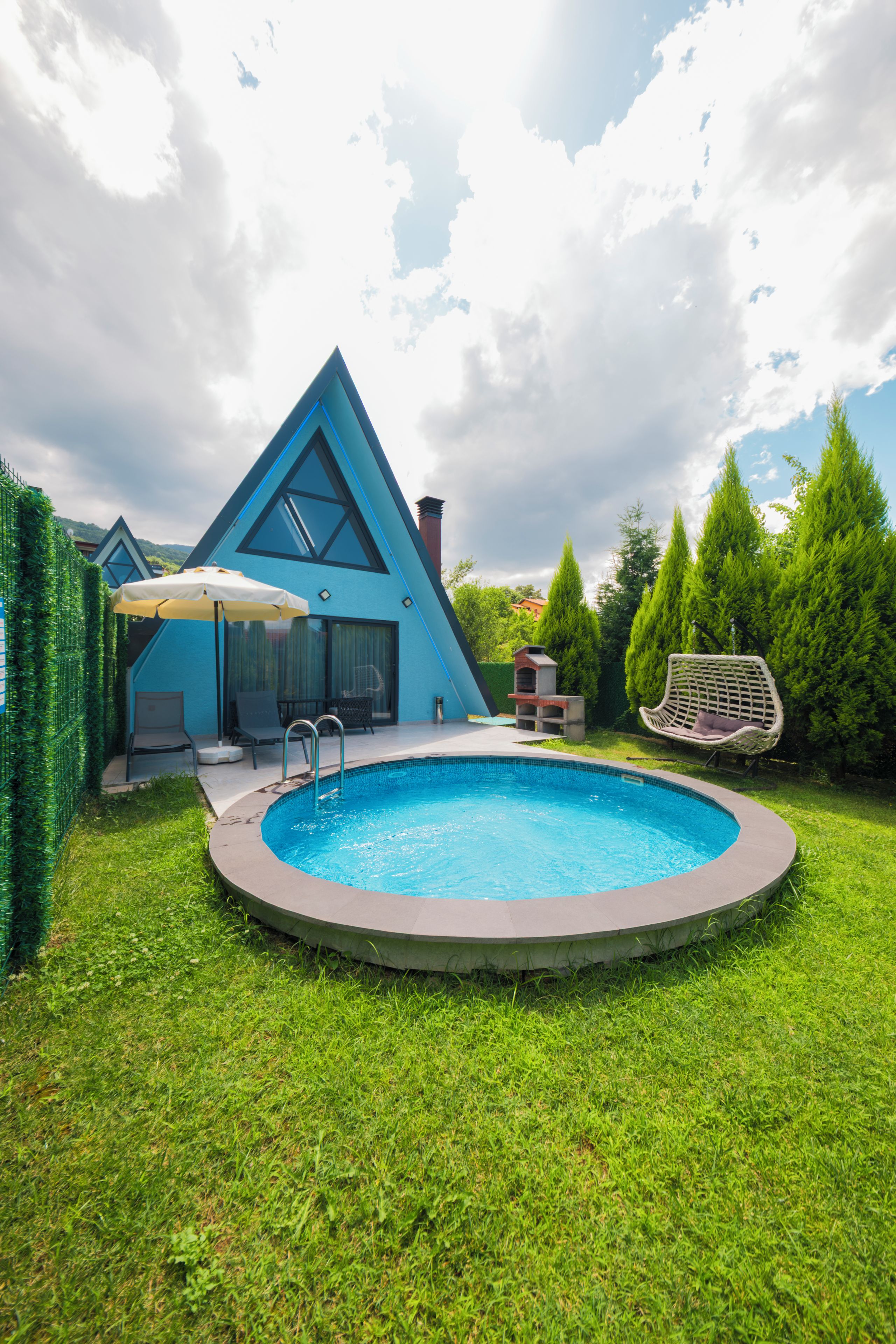 Piscina com um edifício triangular ao fundo.