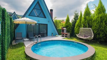 Piscina com um edifício triangular ao fundo.
