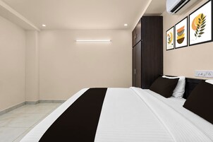 Quarto de hotel moderno com cama, guarda-roupa e ar condicionado fixado na parede.