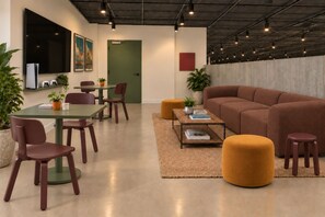 Uma sala de estar moderna com sofá seccional, mesa de centro e área de jantar com cadeiras e mesa.