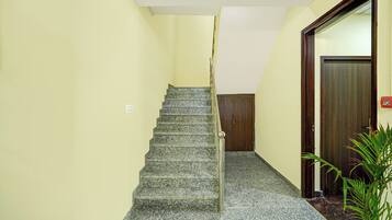 Uma escada com corrimão leva a uma porta de madeira no topo.