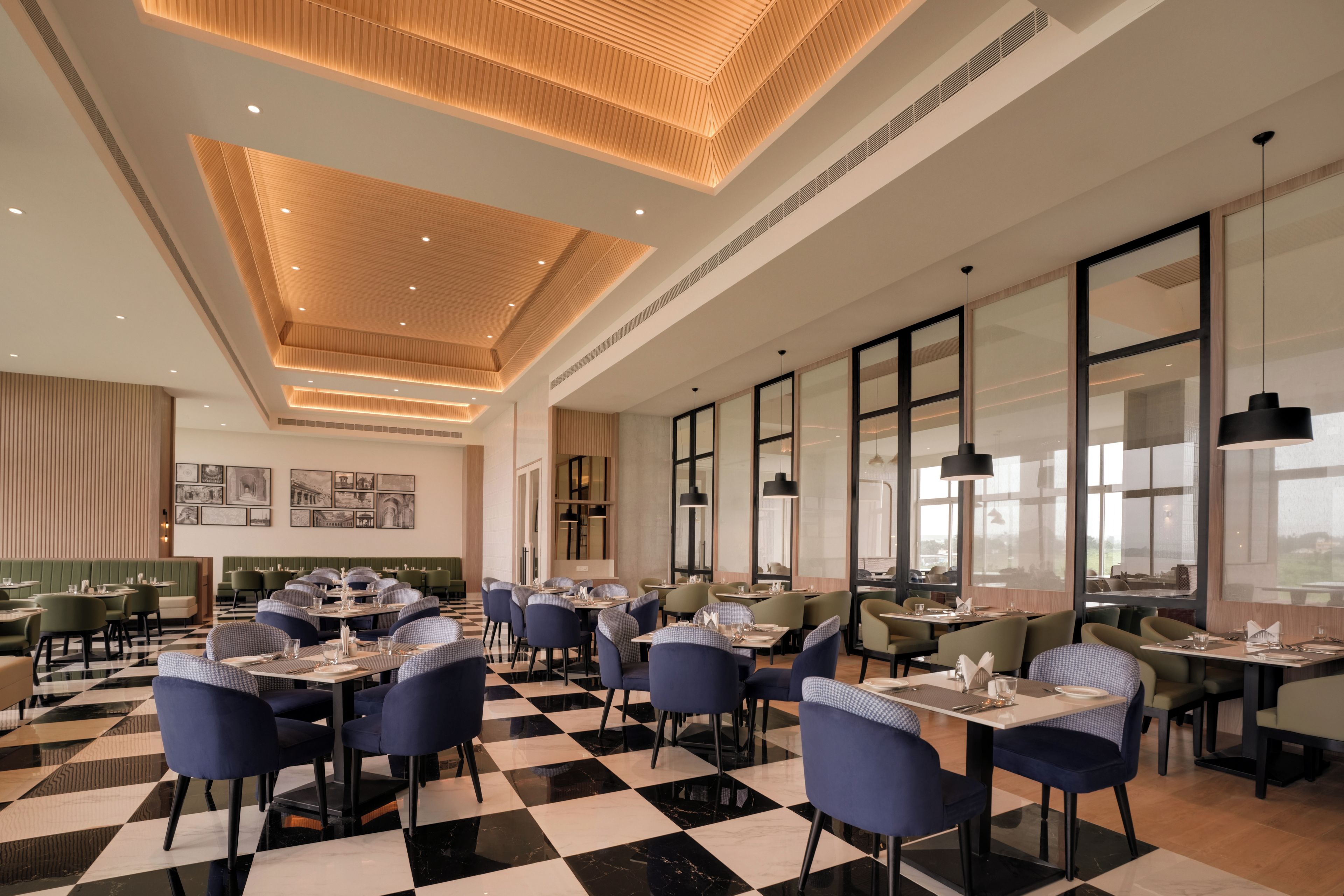 Interior de restaurante moderno com chão quadriculado, várias mesas e cadeiras.
