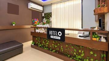 Bancada de recepção de hotel com sinal indicando que é administrado pela OYO.