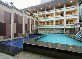 Hotel com piscina, várias varandas e design arquitetônico moderno.