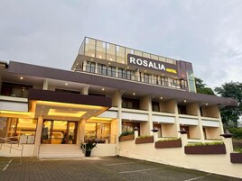 Hotel com fachada moderna, entrada destacada e placa com o nome.