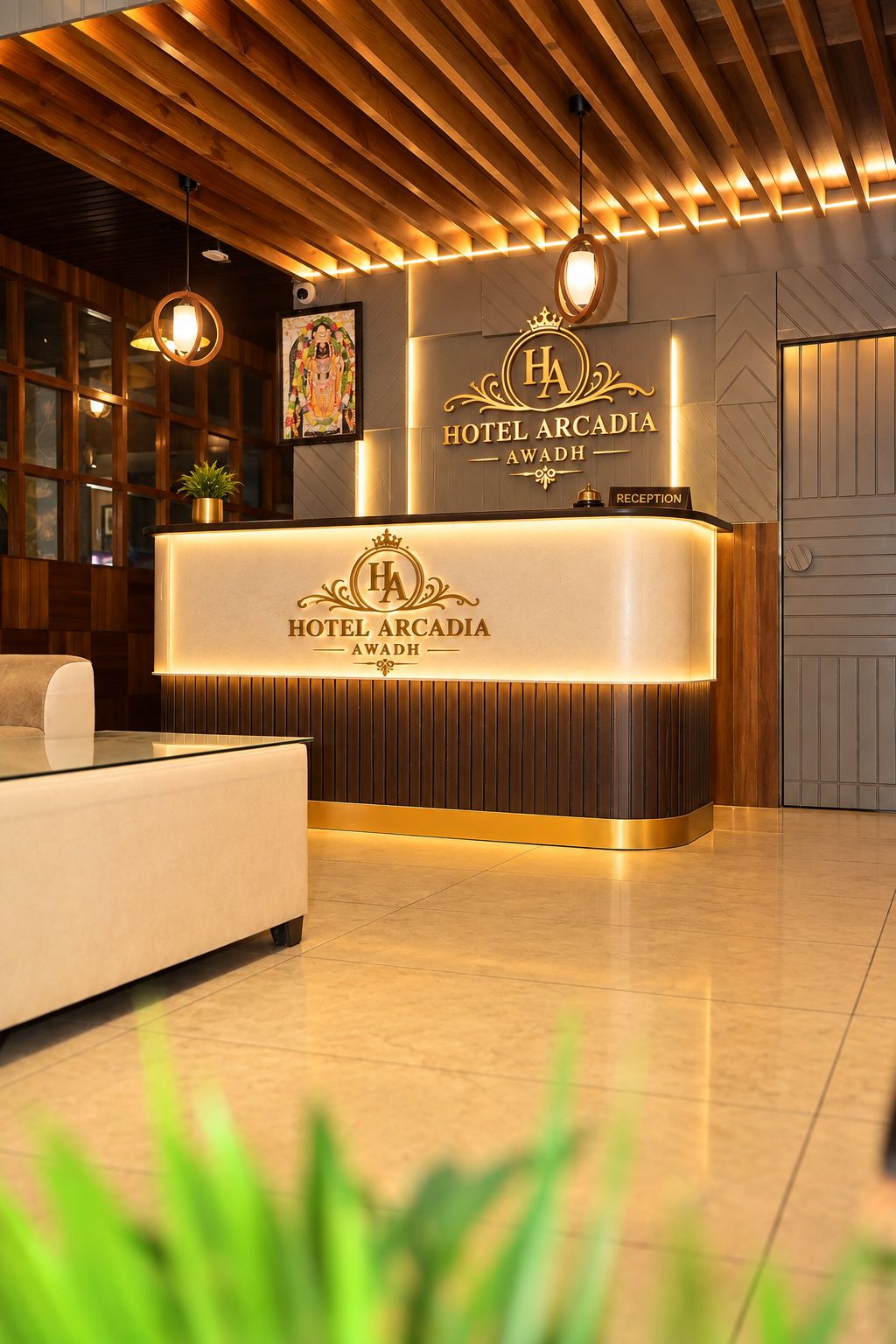 Uma área de recepção de hotel com balcão, um quadro na parede e a placa da recepção.