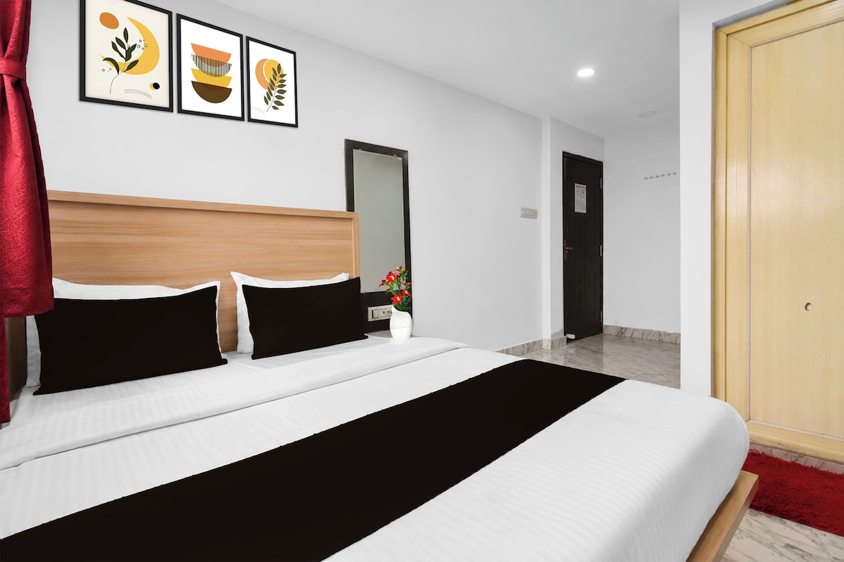 Quarto de hotel com cama, espelho, porta e decoração na parede.