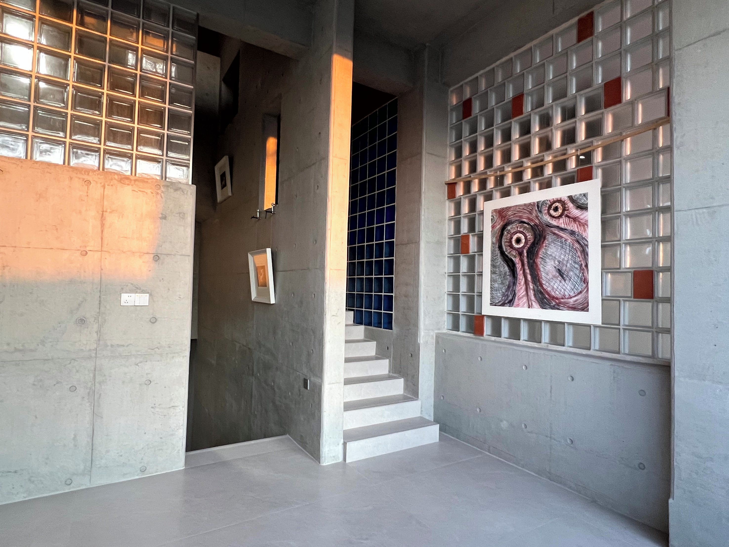 Decoração moderna com escada de concreto, obra de arte emoldurada e parede estampada.