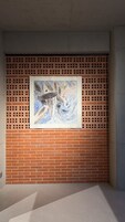Quarto com parede de tijolos e uma obra de arte emoldurada.