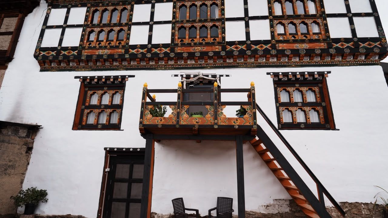 Um edifício com varanda, porta e escadaria.