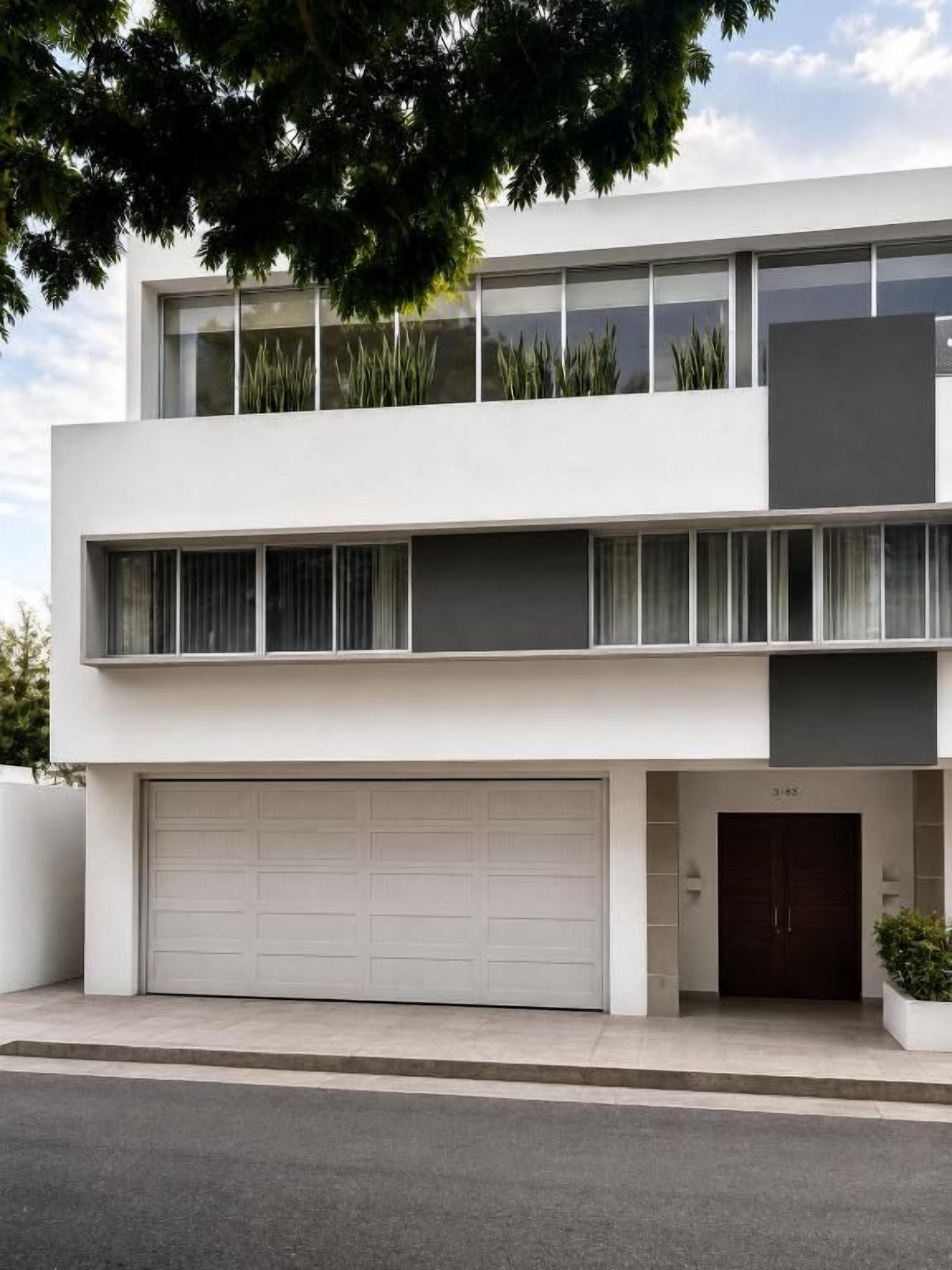 Um edifício moderno de dois andares com telhado plano, janelas amplas e garagem.