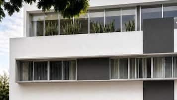 Um edifício moderno de dois andares com telhado plano, janelas amplas e garagem.