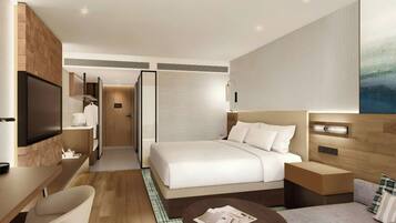 Quarto de hotel moderno com uma cama grande, televisão de tela plana, escrivaninha e área de estar.