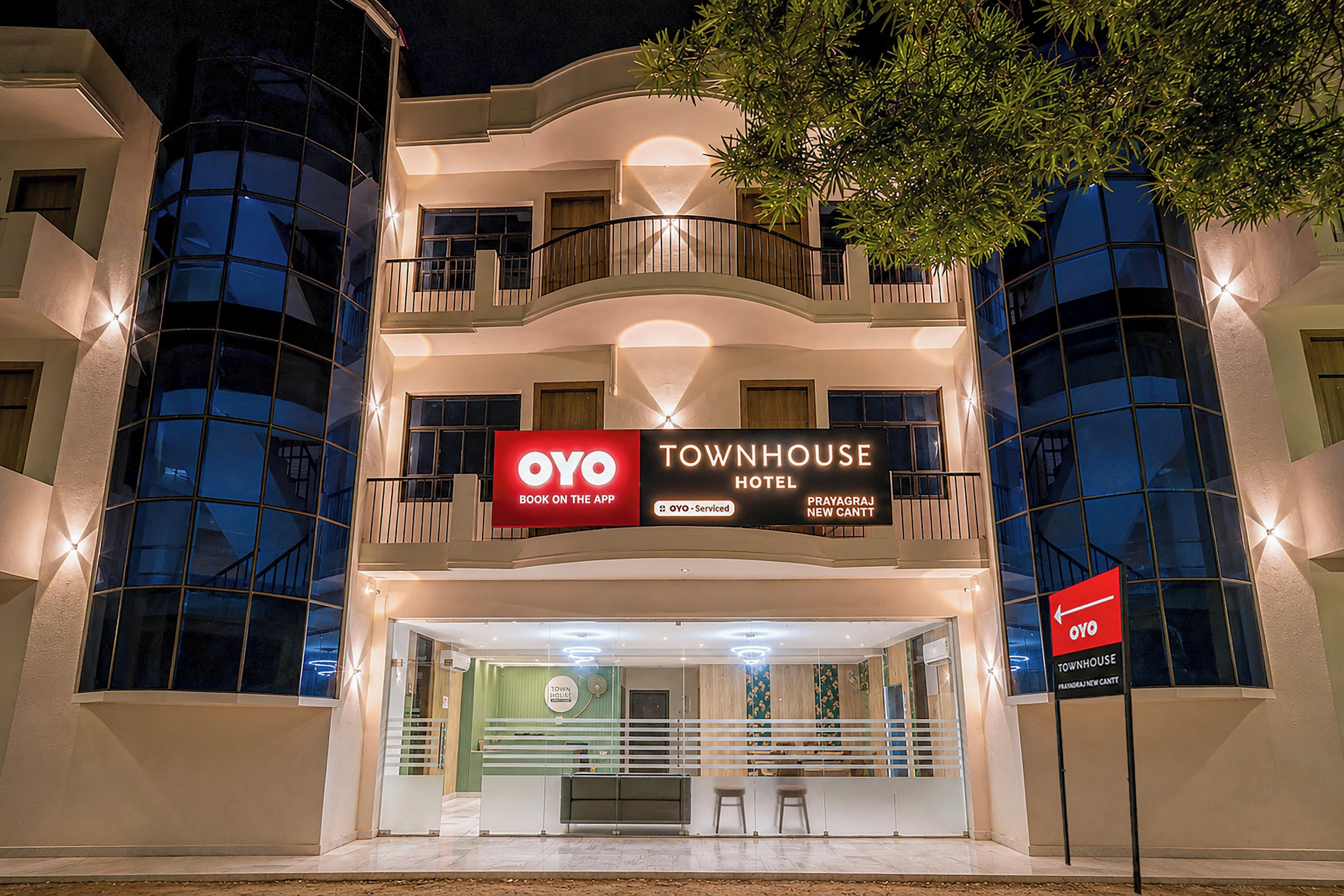 Um hotel com vários andares, com destaque para a placa 'OYO Townhouse Hotel' e a funcionalidade 'Reserve no Aplicativo'.