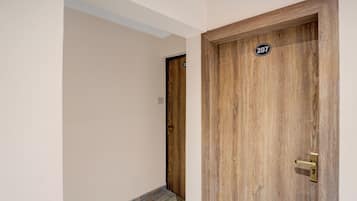 Uma porta de madeira com puxador de latão e placa numerada com o número 207.
