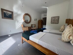 Quarto com duas camas, uma cabeceira de madeira, um painel de parede tecido e uma obra de arte emoldurada.
