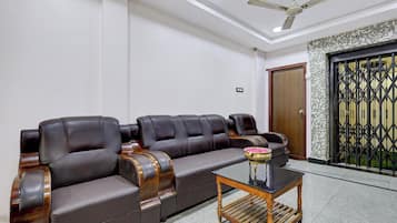 Uma sala de estar com sofá seccional, mesa de centro e ventilador de teto.
