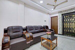 Uma sala de estar com sofá seccional, mesa de centro e ventilador de teto.