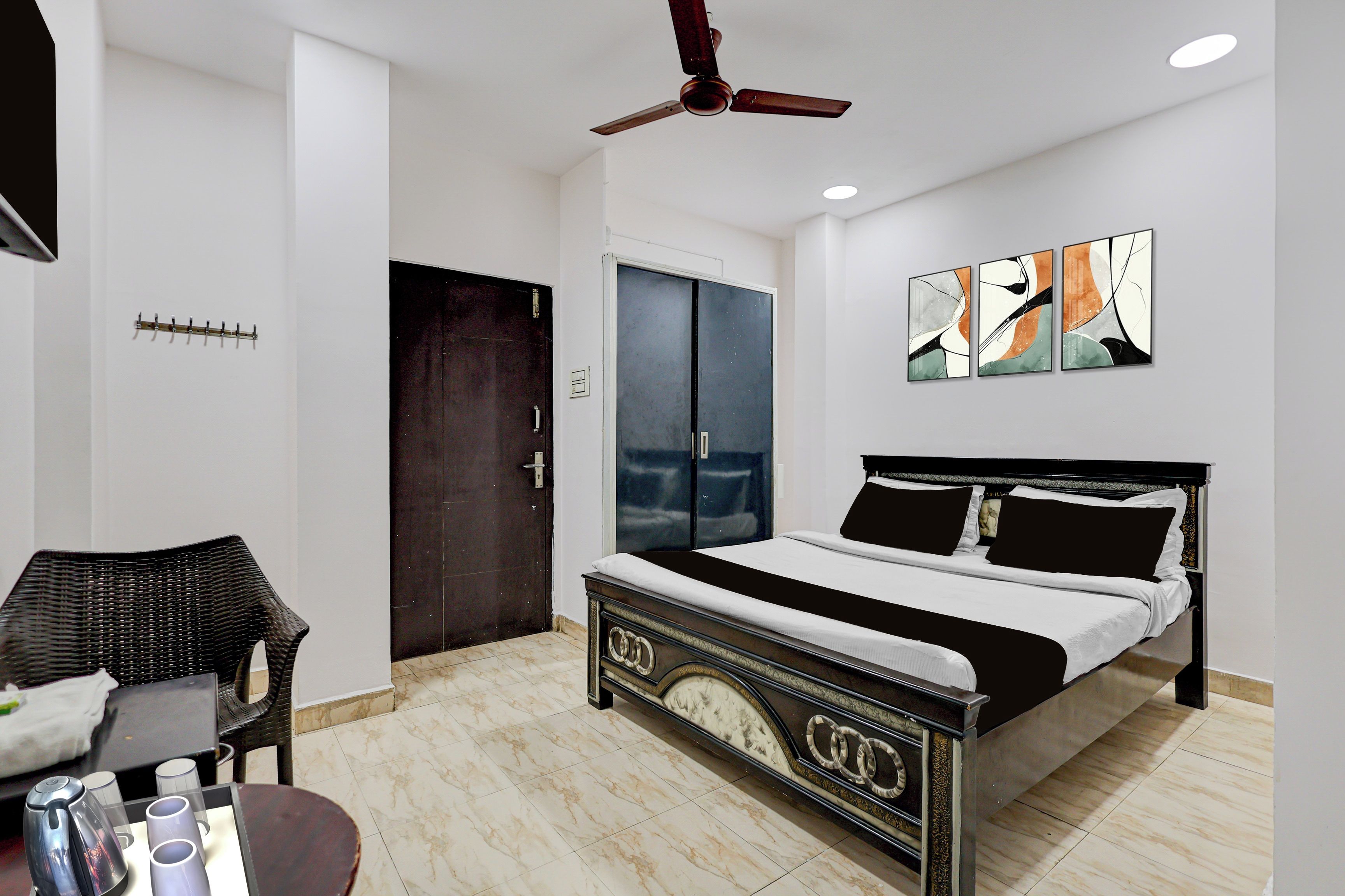 Quarto com cama, cadeira, escrivaninha, guarda-roupa e ventilador de teto.